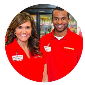 Young man and woman in red Family Dollar shirts in a store.