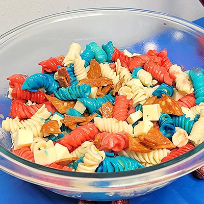 Blog idea: a glass bowl of pasta salad with cheese, pepperoni, and red ...