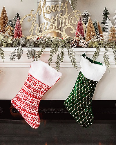 Stockings hung over a fireplace in different holiday colors and prints ...