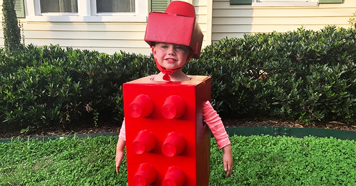 A child dressed in a costume to look like a red Lego.