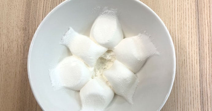 A white bowl with melted marshmallows in it.