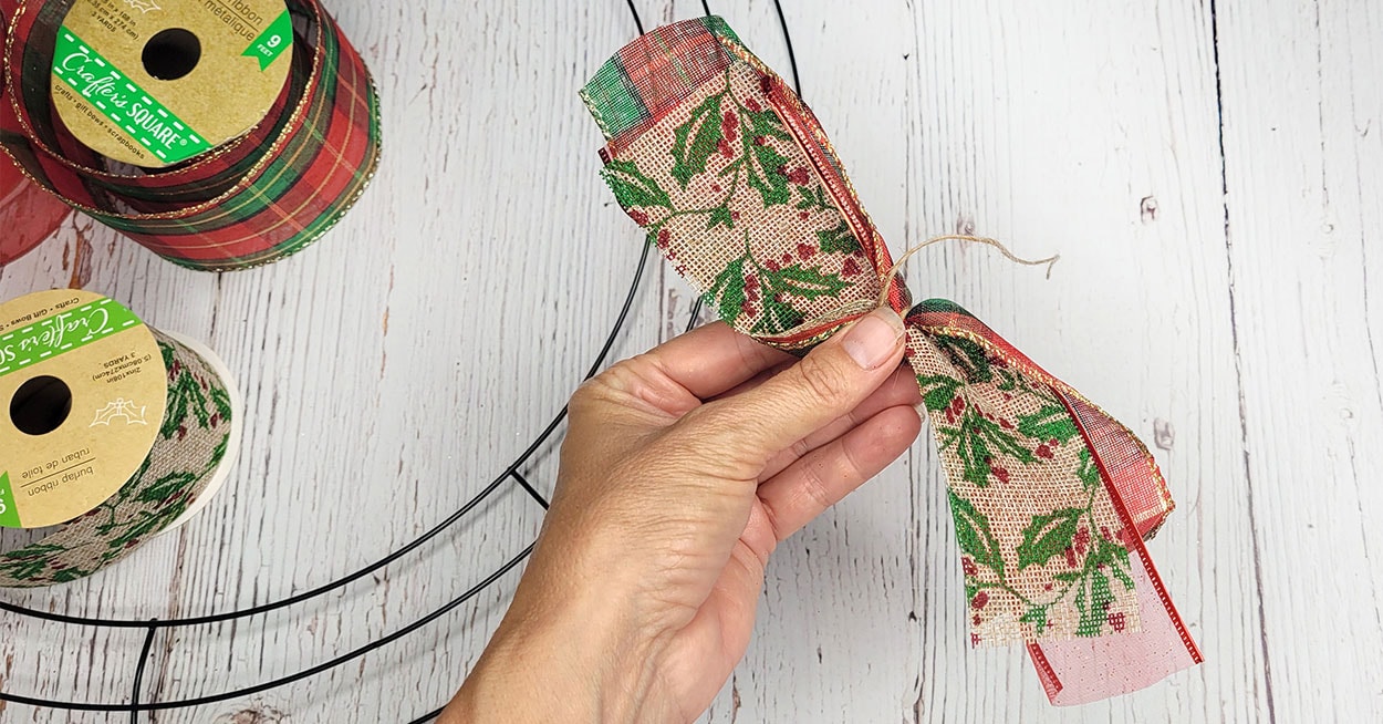 hand holding three pieces of ribbon tied with twine