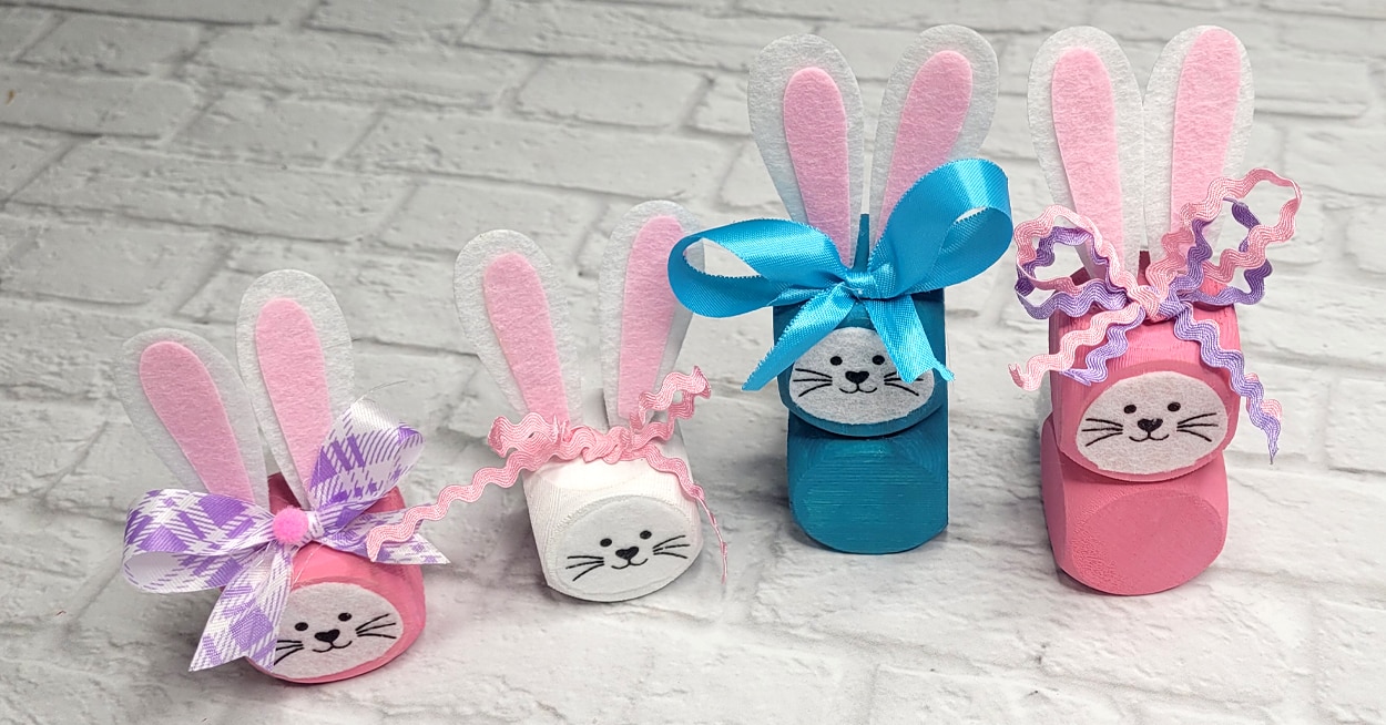 Easter bunny craft made from wooden cubes with bows and faces.