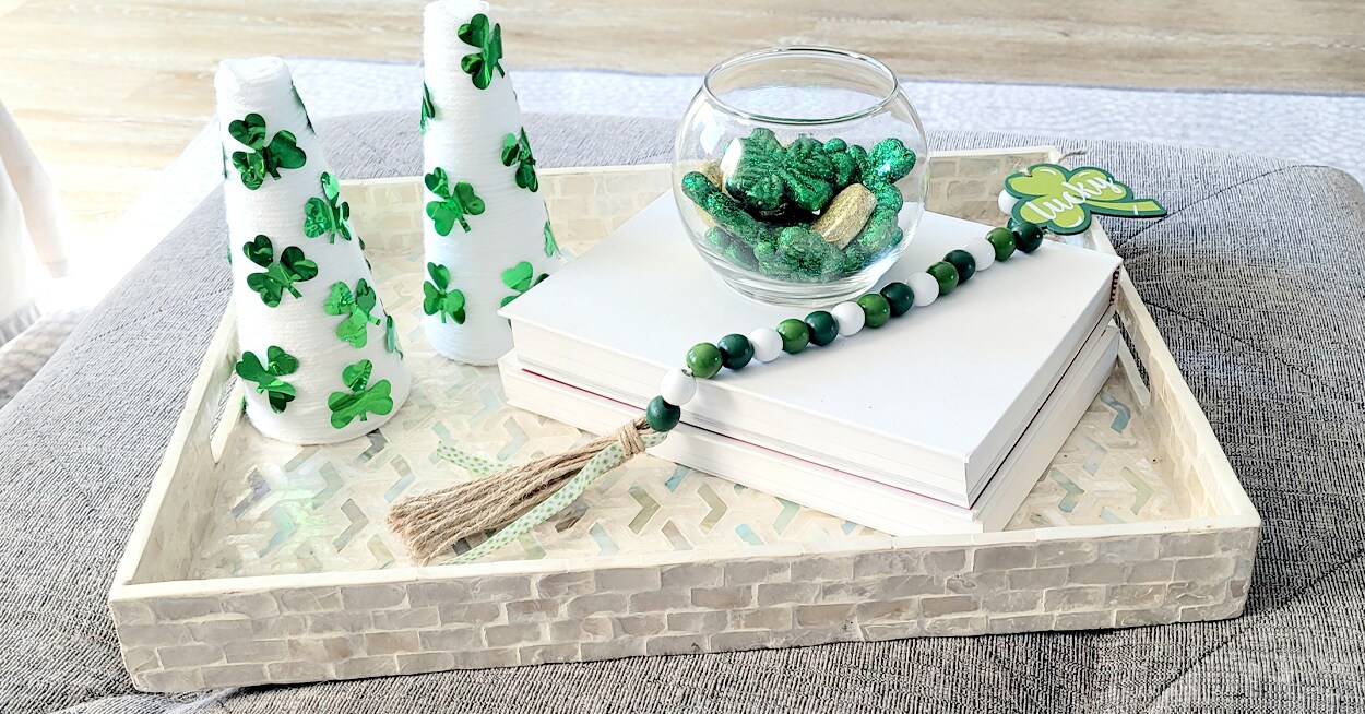 Two cones wrapped with white yarn and embellished with green foil ...
