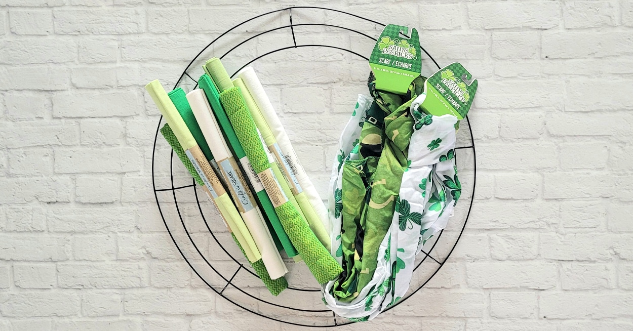 A round wire wreath form with fabric and scarves on it.