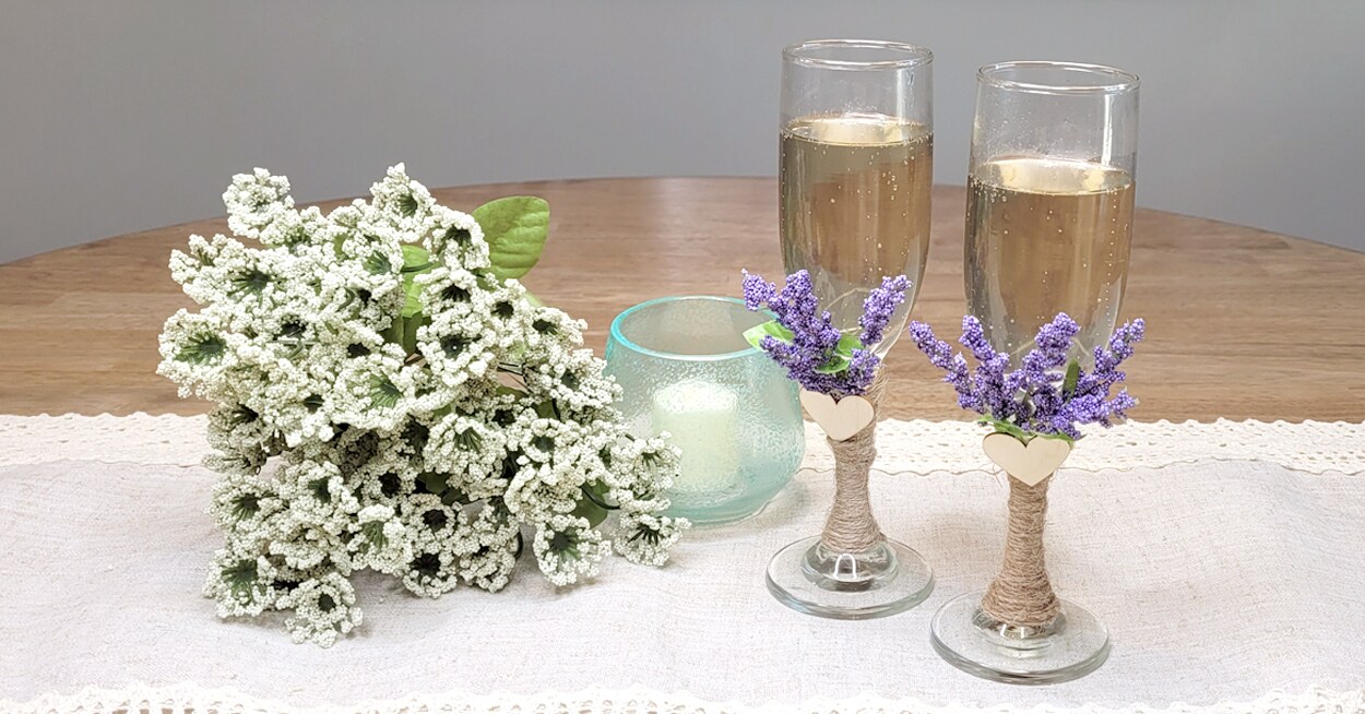 Two champagne flutes decorated with twine, lavender, and a wooden heart ...