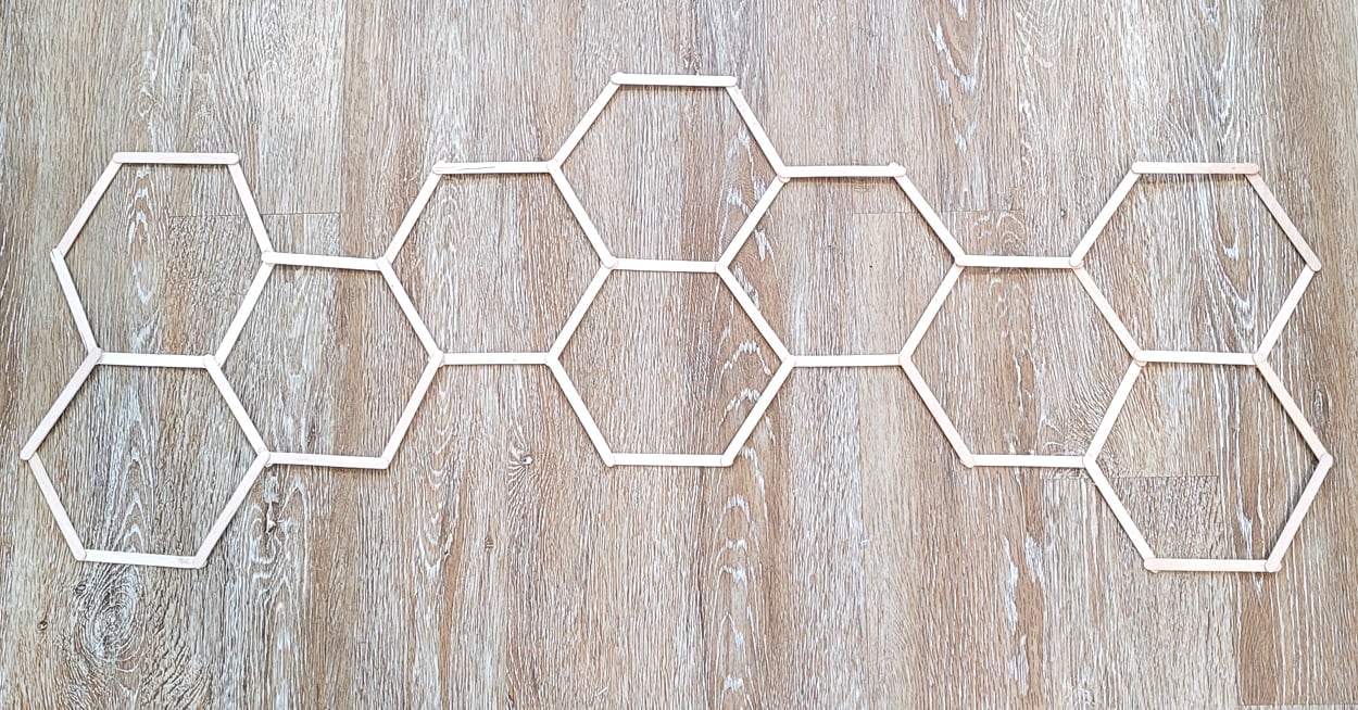 Ten hexagons made from popsicle sticks that are glued together.