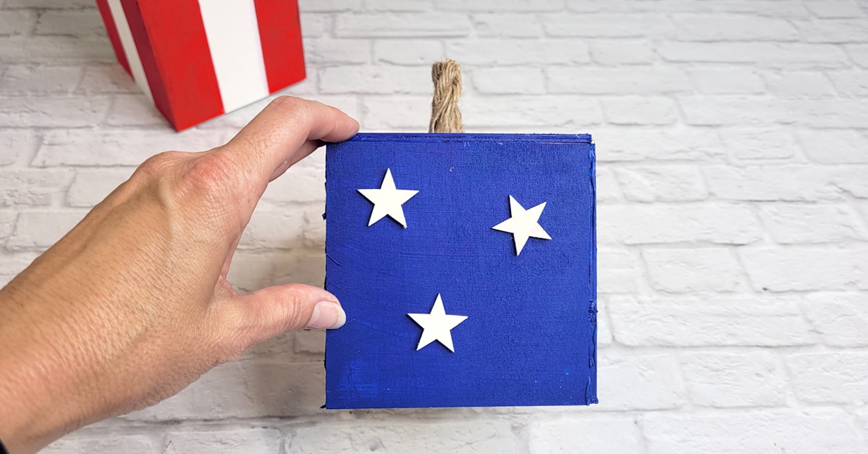 A hand holding a blue box with stars on it.