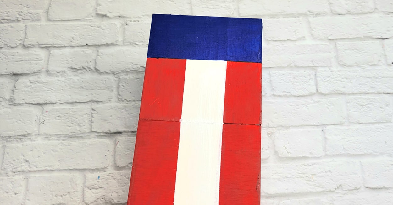 A wooden box with a blue stripe, and bowls of red and blue paint with ...