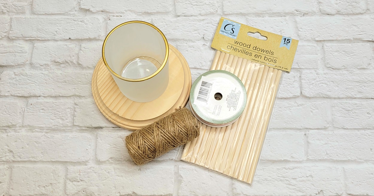 A round wooden piece, a glass candleholder, twine, a package of dowel ...