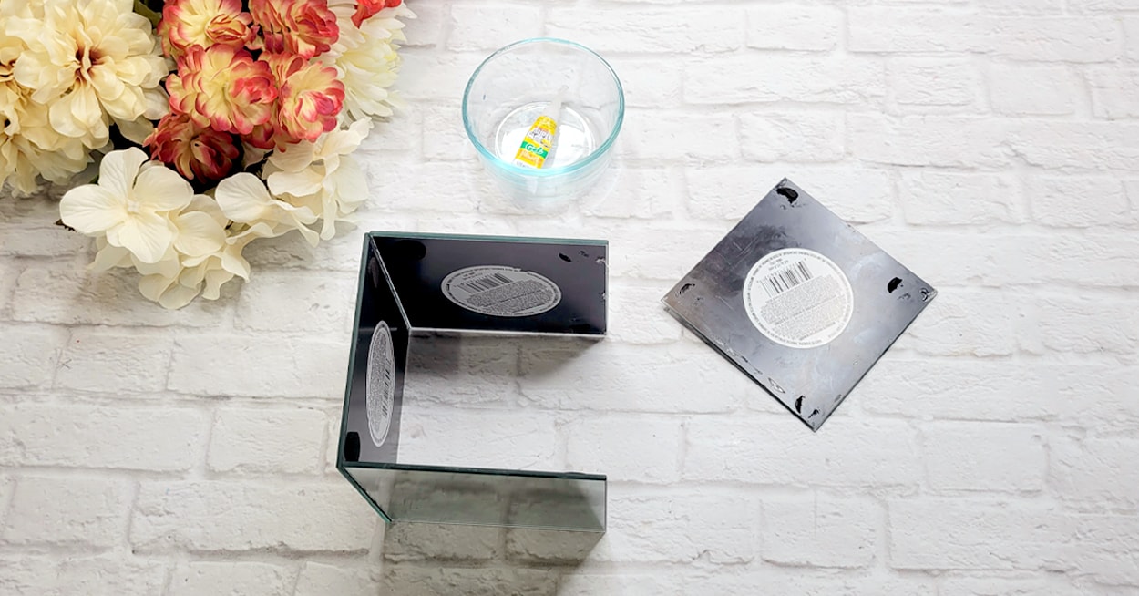 Flowers, a square made from mirrored candleholders, and a bowl with ...