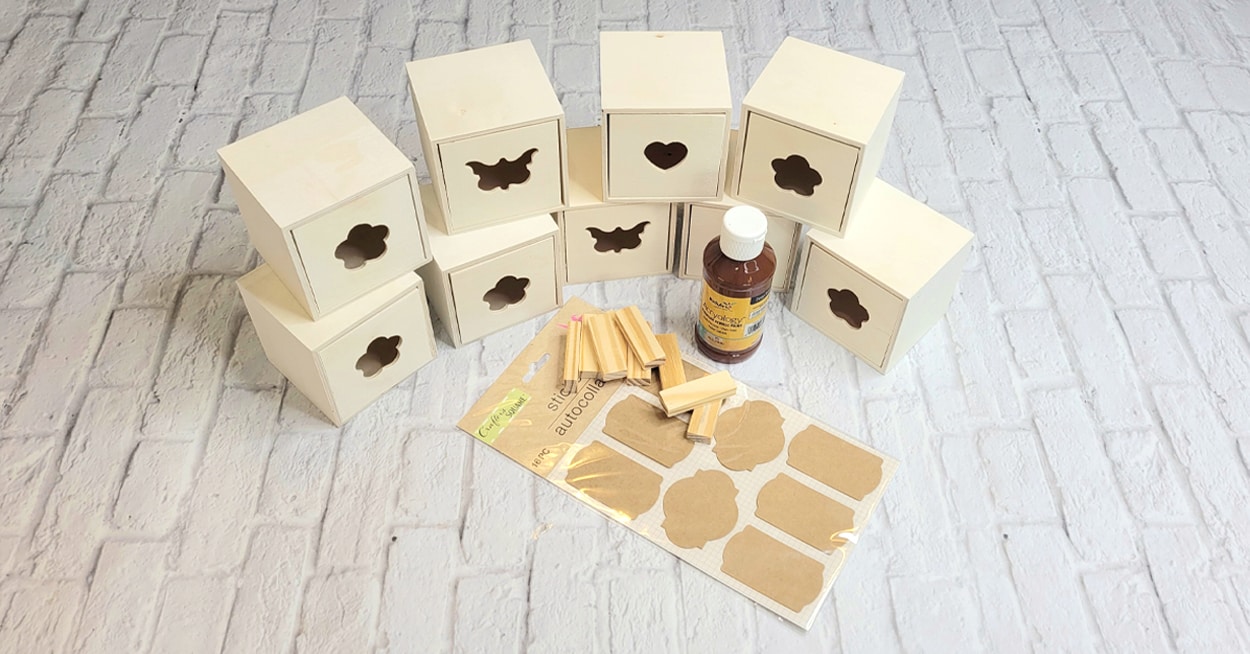 Nine small wooden boxes, a sheet of labels, and brown paint.