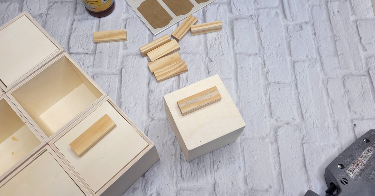 Small wooden boxes, small wooden blocks, and a sheet of labels.