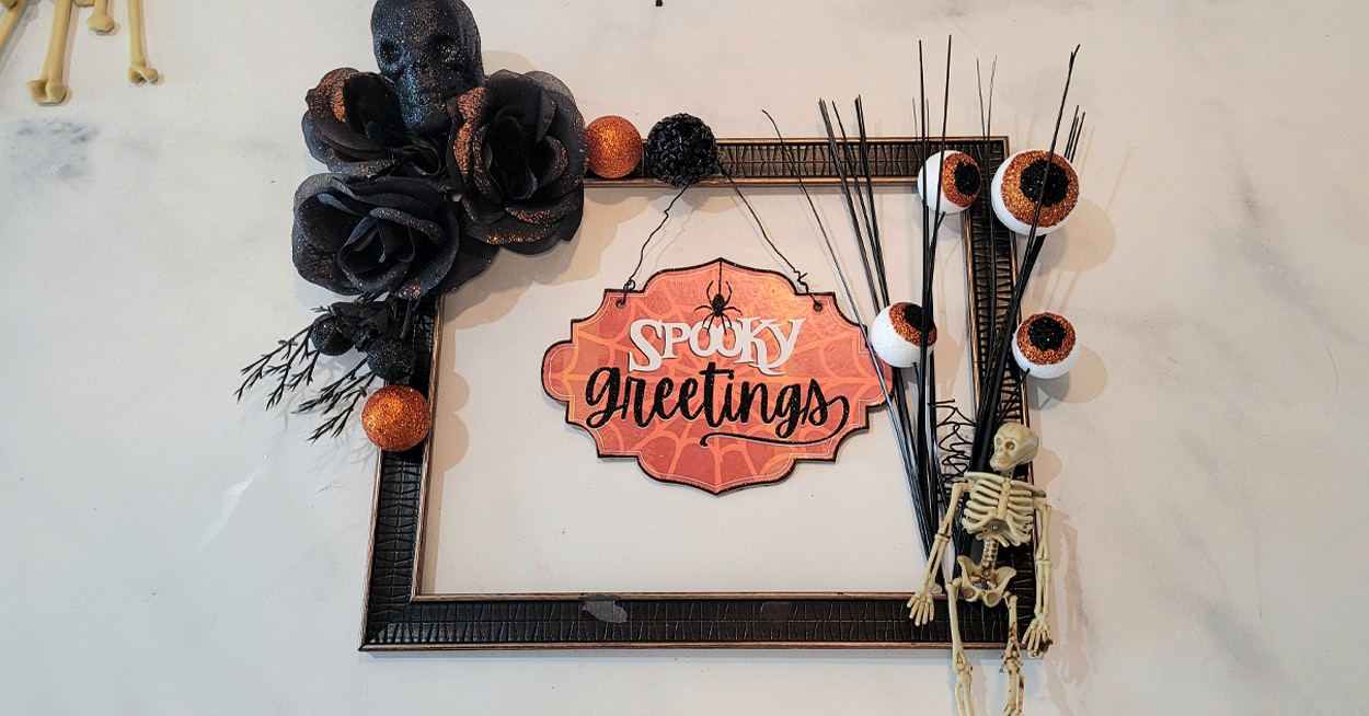 A frame with a Halloween sign and plastic skeleton on it.