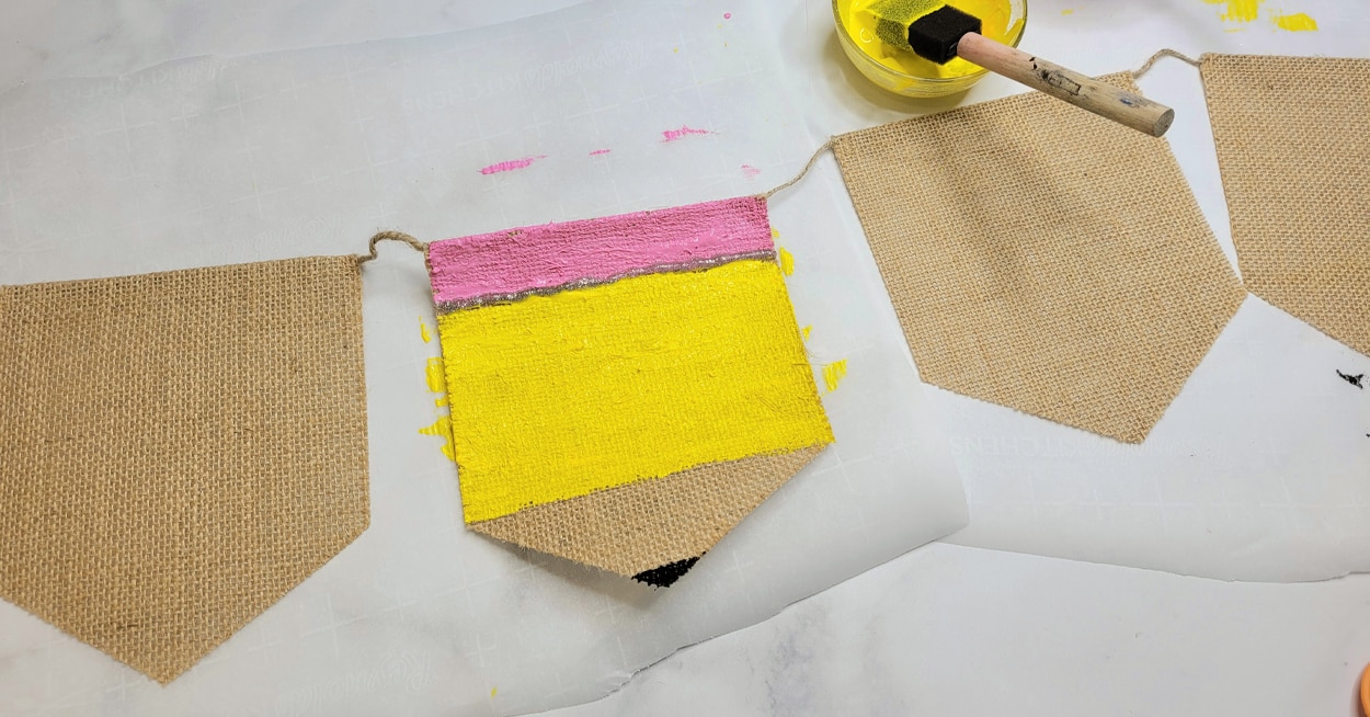 A burlap banner painted to look like a pencil.