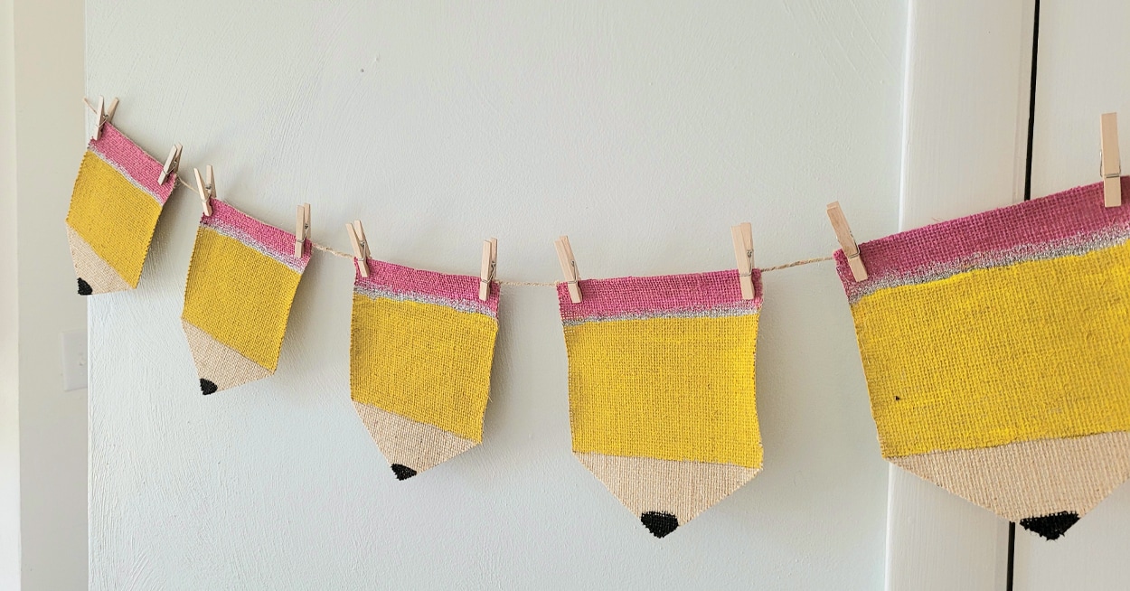 A burlap banner painted to look like pencils.
