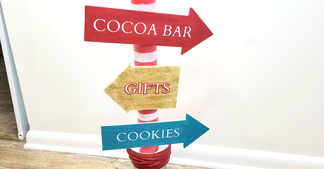 Arrow signs with “cocoa bar”, “gifts”, and “cookies” written on them on ...