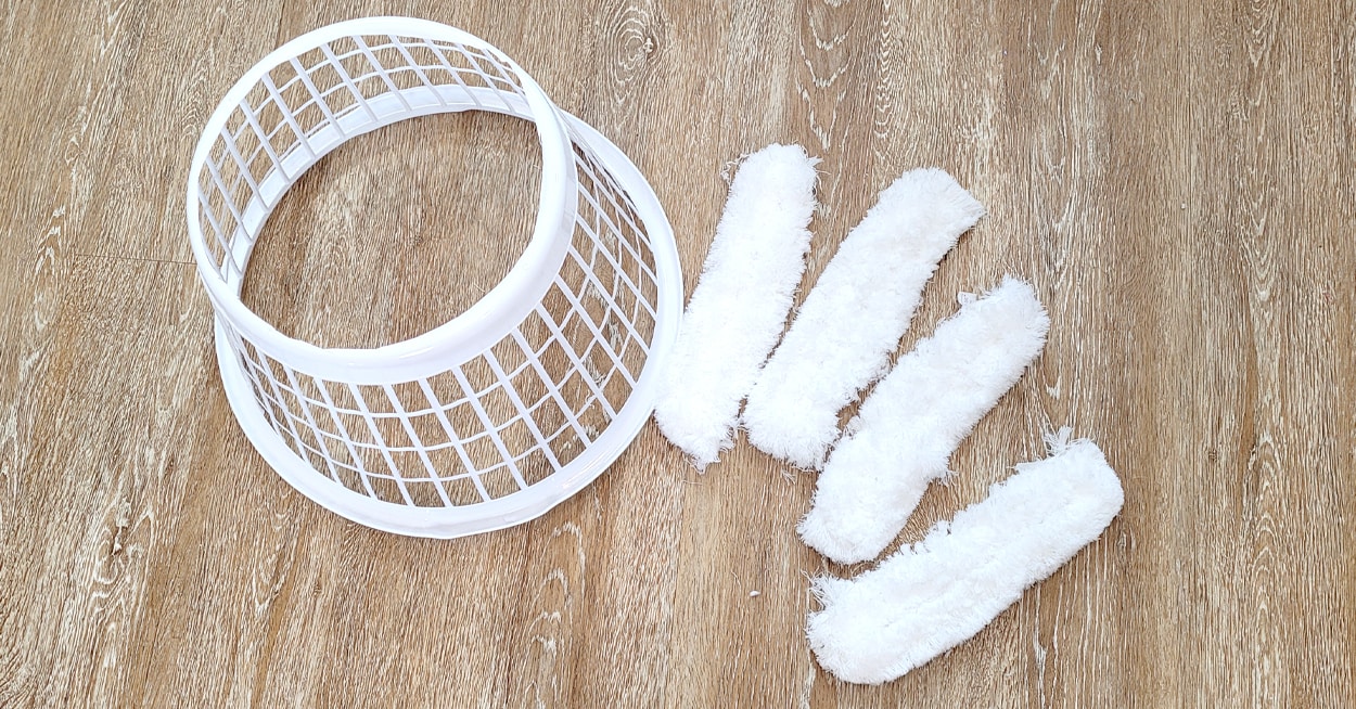 A laundry basket with the bottom cut out and 4 white mop pads.