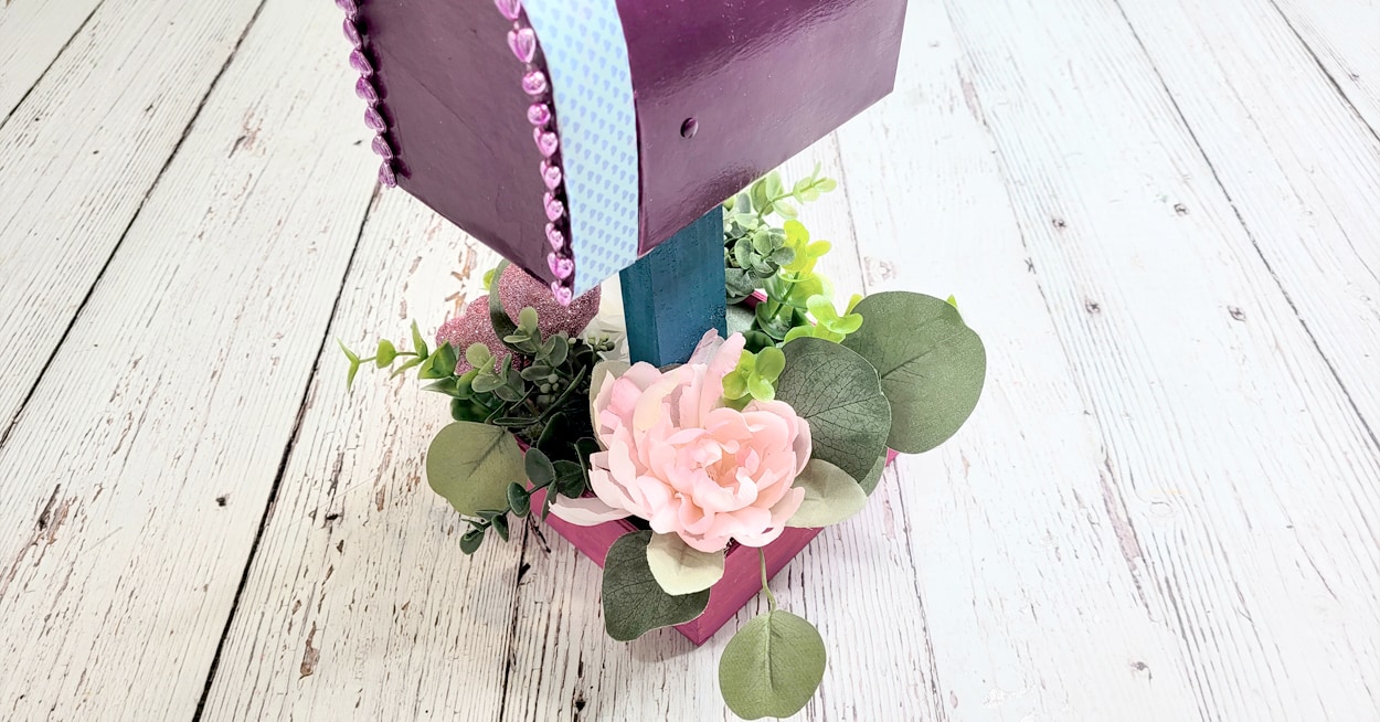 Flowers and a purple decorative mailbox.