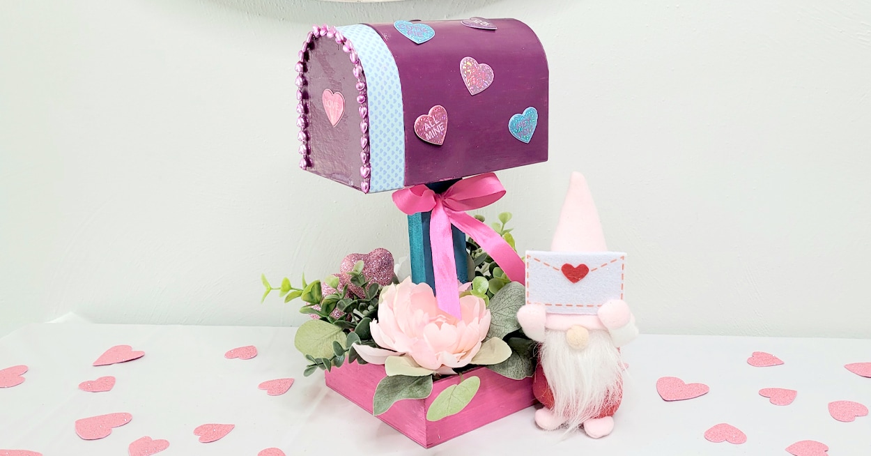 A decorative Valentine’s mailbox on a table with pink glitter hearts ...