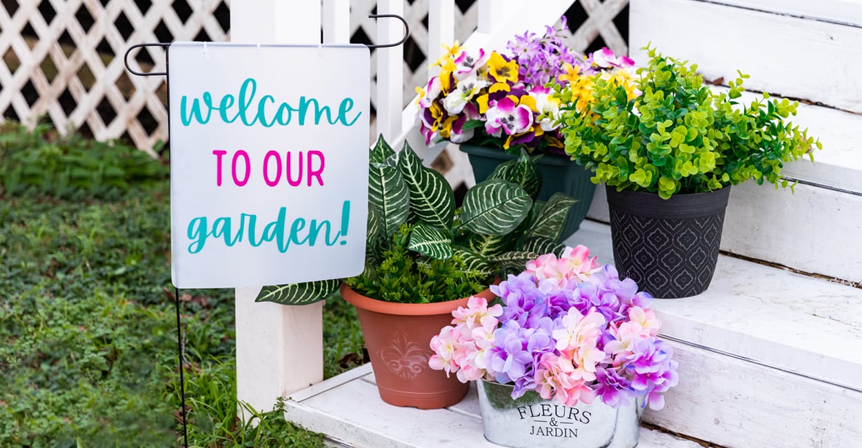 A DIY garden sign reading "welcome to our garden" beside porch steps ...