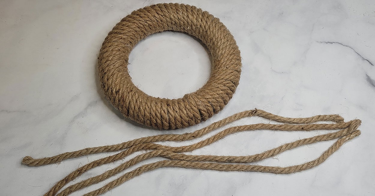 A small foam wreath with nautical rope wrapped around it and 4 pieces ...