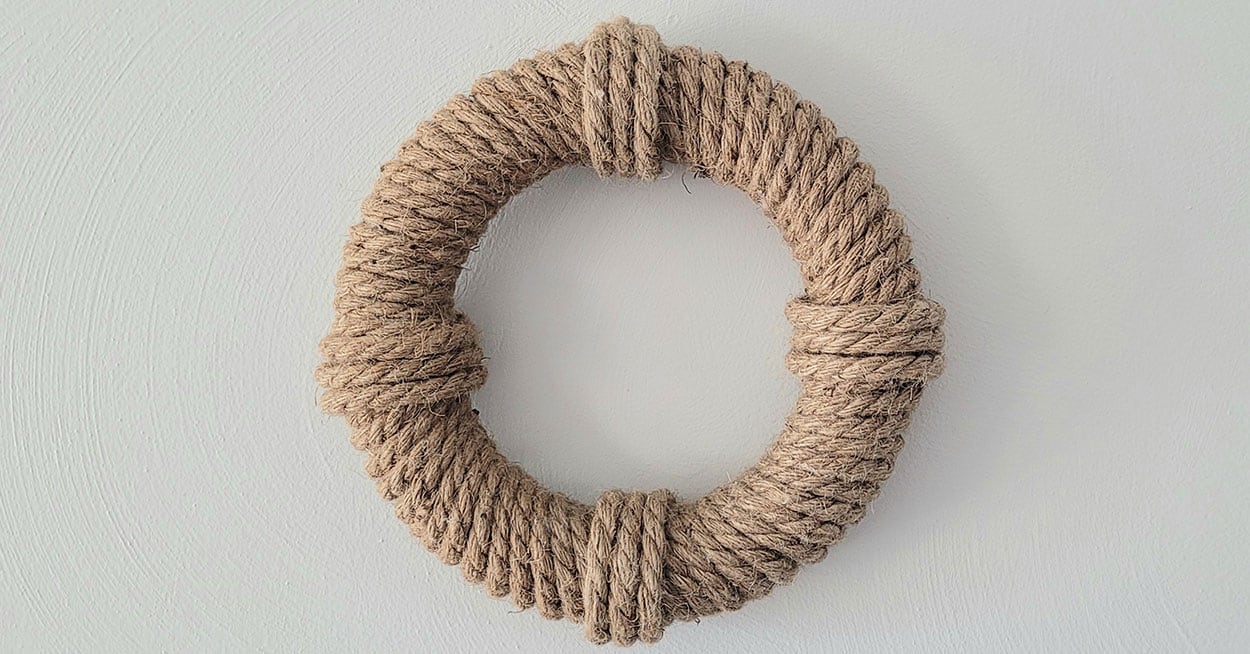 A round buoy wreath made with nautical rope on a wall.